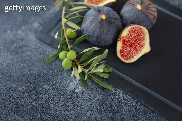 fresh ripe figs fruit and olive branch on dark table (1419583730) - 게티이미지뱅크