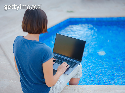Young business woman working at computer by hotel pool. 이미지 (1412466994 ...