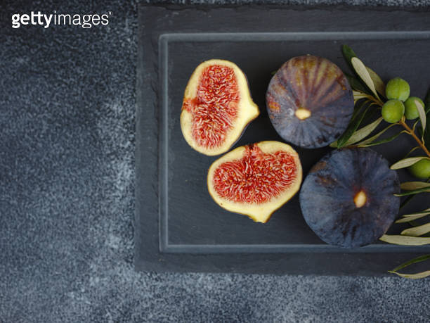 fresh ripe figs fruit and olive branch on dark table (1419597136) - 게티이미지뱅크