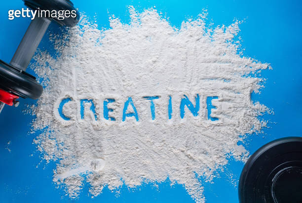 the word creatine written on a white powder. wellness concept ...