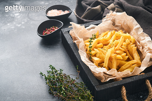 French fries. Tasty French fries server on parchment paper on wooden ...