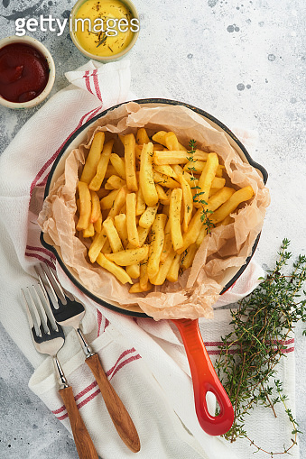 French fries. Tasty French fries server in red cast iron skillet with ...
