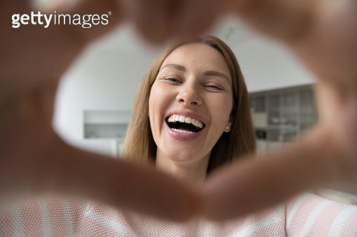 Happy woman showing symbol of love, smile staring at camera (1436376605 ...