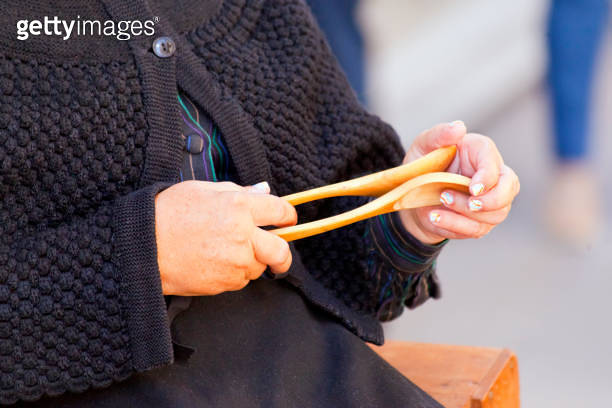 Traditional folk female musician playing wooden spoons as percussion ...