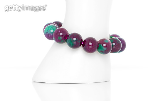 Ruby Zoisite bracelet on a white display stand. Collection of natural ...