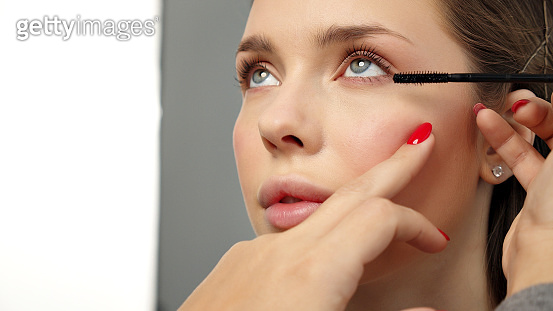 Make-up artist in photo studio doing makeup for beautiful girl. Woman ...