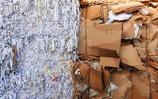 stack of shredded waste paper and cardboard in front of a recycling ...