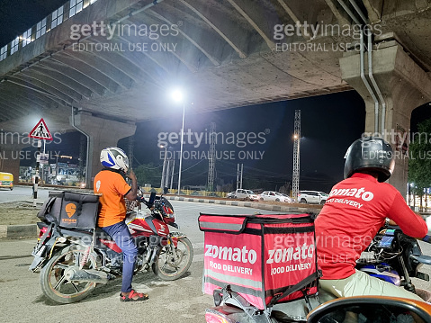 Zomato bike rider delivery boy looking at rider from swiggy food tech ...