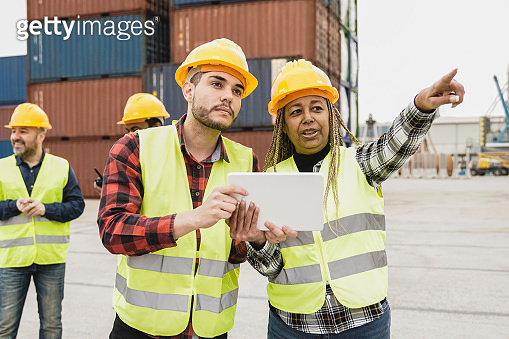 Industrial multiracial operators working at container cargo logistics ...