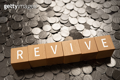 Wooden blocks with "REVIVE" text of concept and coins. (1416166409 ...