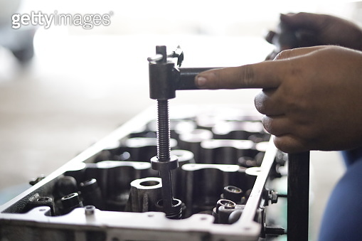 mechanics install valve seals, assemble car engine header cylinders ...