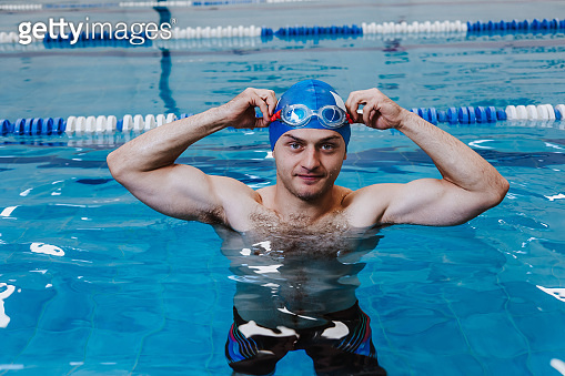 hispanic young man swimmer athlete wearing cap in a swimming training ...