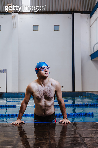 hispanic young man swimmer athlete wearing cap in a swimming training ...