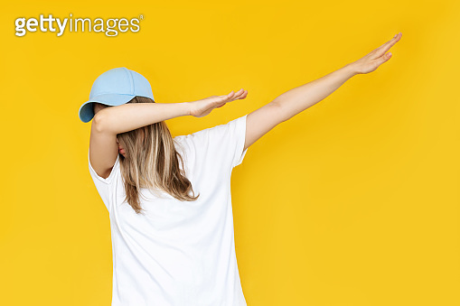 Young woman covers her face with one arm and takes the other aside ...