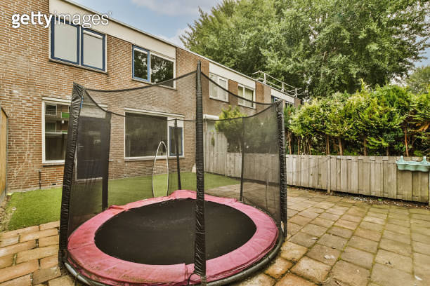 a trampoline in a backyard with a house 이미지 (1442284779) - 게티이미지뱅크