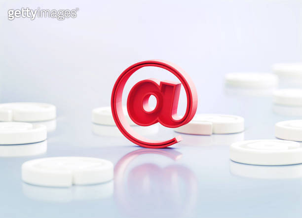 Red At Symbol Sitting Amid White At Symbols On White Reflective ...