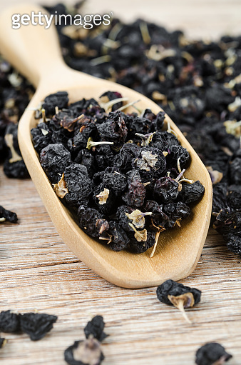 Black wolfberries or black goji berries, in a wooden spoon. 이미지 ...