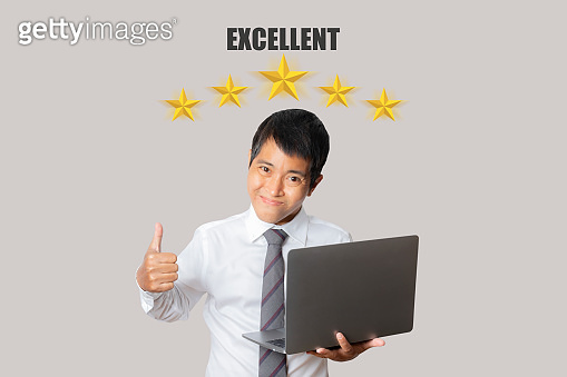 Businessman using laptop computer with five star icon to give ...