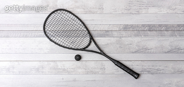 Black squash racket and ball on grey court. Horizontal sport theme ...