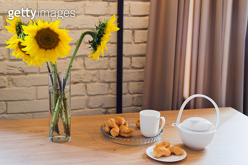 Bouquet of sunflowers on the dining table. Breakfast or snack with tea ...
