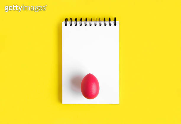 Notebook with red Easter Egg. Spiral notepad on spring yellow ...