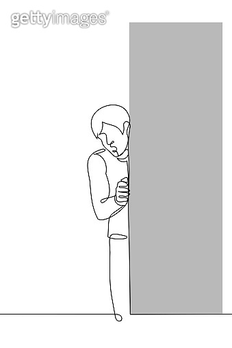 man hides behind the corner of the wall and eavesdrops and looks with ...