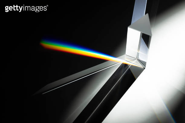 Triangular Prism dispersing sun beam splitting into a spectrum on white ...