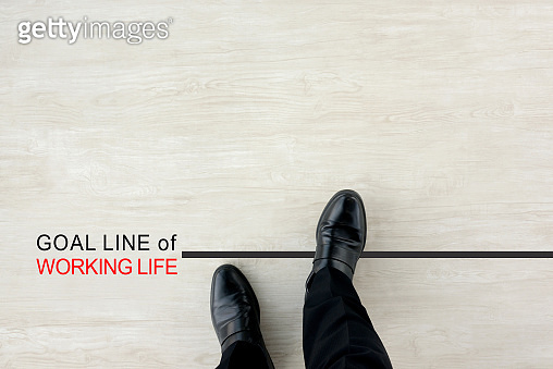 Business man stepping over goal line for finishing working life ...