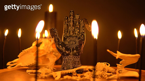 Fortune teller hand or palmistry on the witch table with animal bones ...
