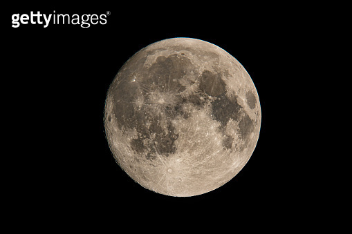 Full moon on dark black sky background, shot from surface of earth with ...