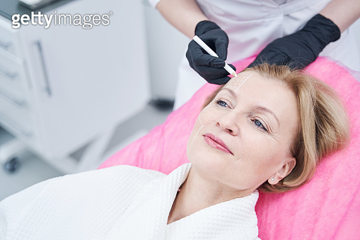 Beautician drawing line on woman face in beauty salon 이미지 (1392751320 ...