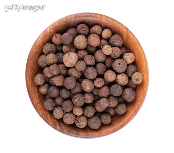 Allspice in wooden bowl, isolated on white background. Jamaican pepper ...