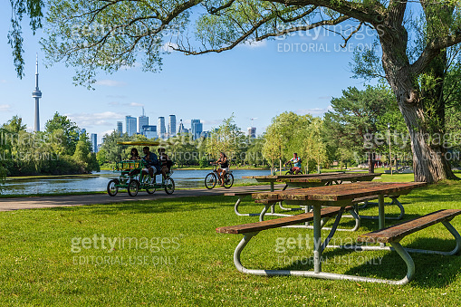 People cycling in the Toronto Islands Park Centre Island. Wooden Bench ...