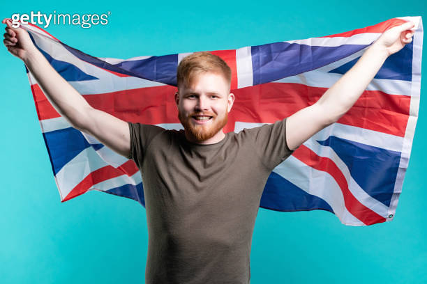 Male portrait of man at the studio with British flag of Great Britain ...