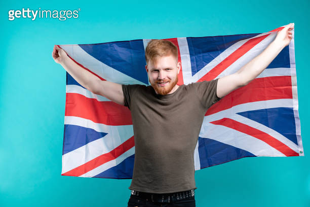 Male portrait of man at the studio with British flag of Great Britain ...