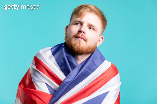 Male portrait of man at the studio with British flag of Great Britain ...