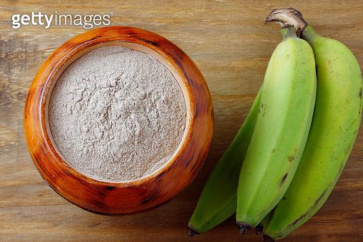 Organic green banana flour, crushed, raw and dry in wooden bowl. gluten ...