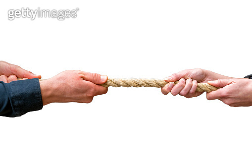 Male and female hands pull in opposite directions on a rope with white ...