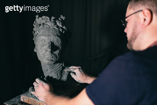 Man sculptor creates sculpt bust clay human woman sculpture. Statue ...