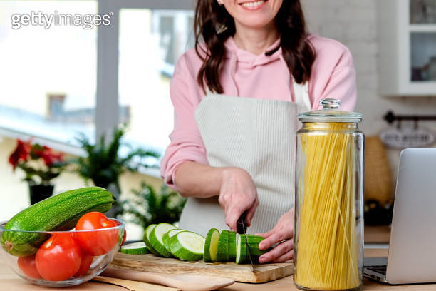 Woman cooking according the tutorial of a online virtual master class ...