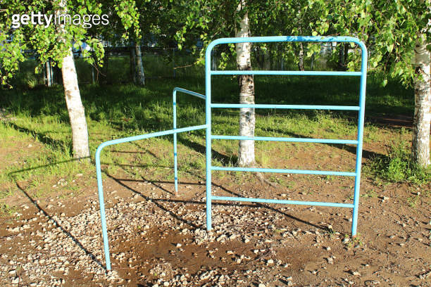 Old blue metal bar for sports. Old horizontal bar on the school grounds ...
