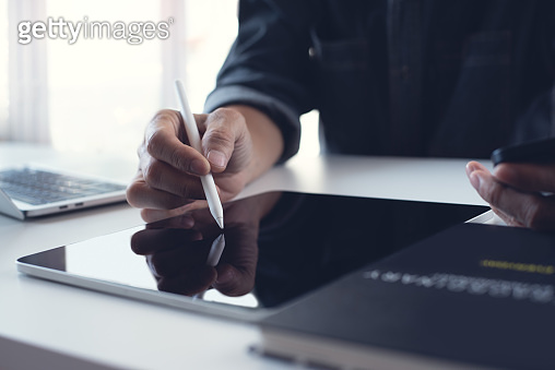 Close up of business man hand using stylus pen signing on digital table ...