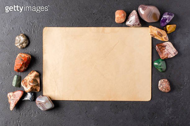 Mineral stones and an old piece of paper. Black concrete background ...