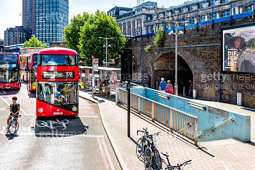 Street by Waterloo underground station with red double decker bus on ...