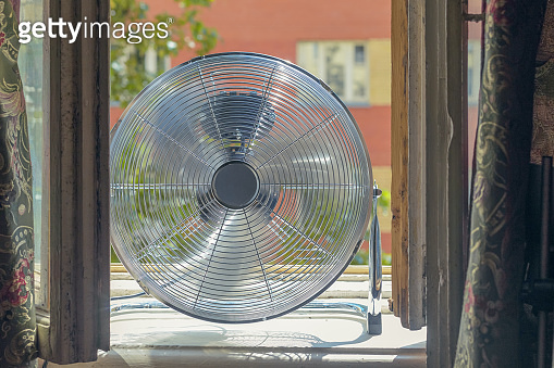 Close up of a big metal fan on the windowsill. 이미지 (1410995796) - 게티이미지뱅크