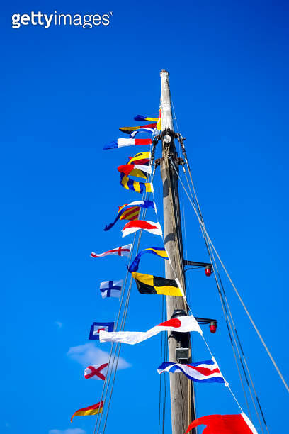International code of signal flags on the mast of a sail boat flying ...