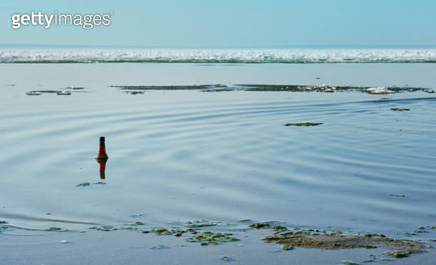 The Volga River in early spring. Ice on the river. A bottle in the ...
