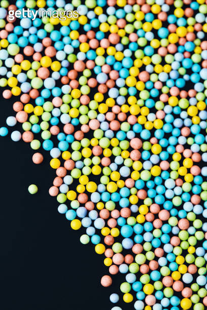 Small colored bead collection on a black background. Conceptual image ...