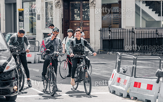 Group of young people cycling in the City of London. Healthy life style ...