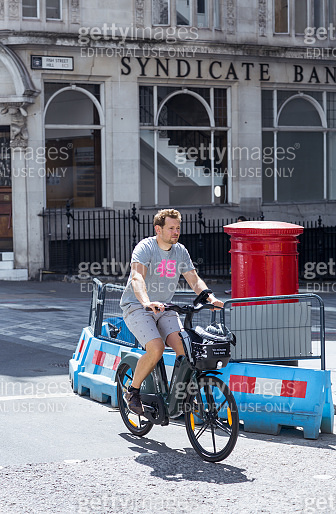 Young man cycling into City of London for work. Healthy life style ...